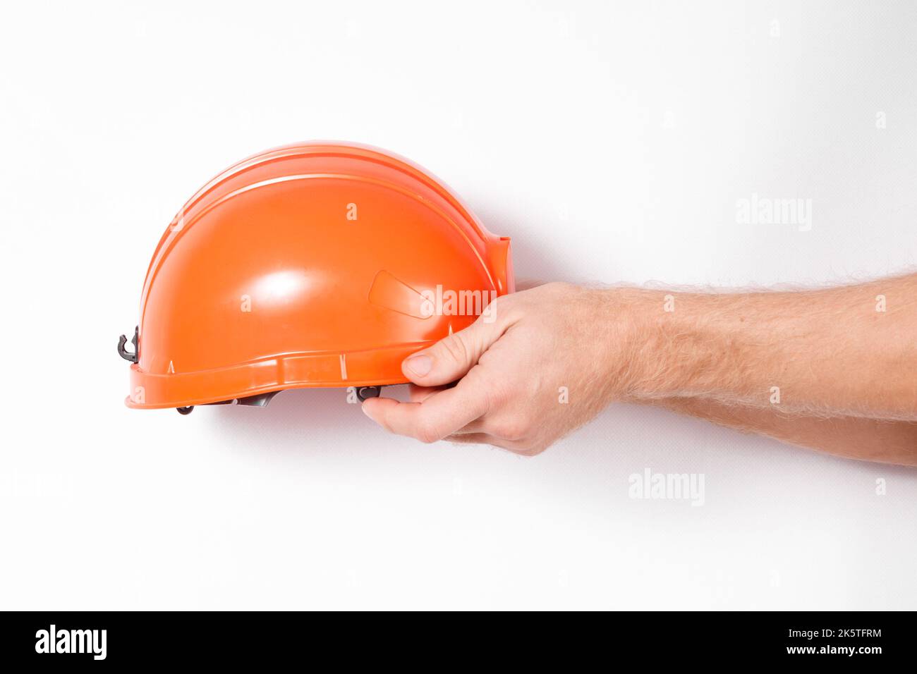 male hand holding orange building paint isolated on white background ...