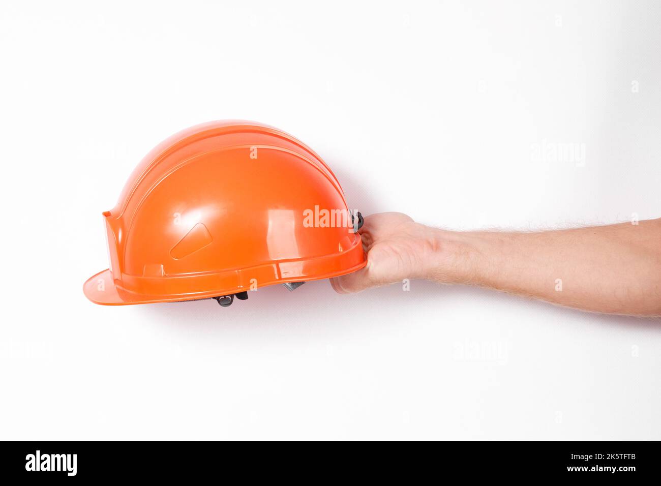 male hand holding orange building paint isolated on white background ...