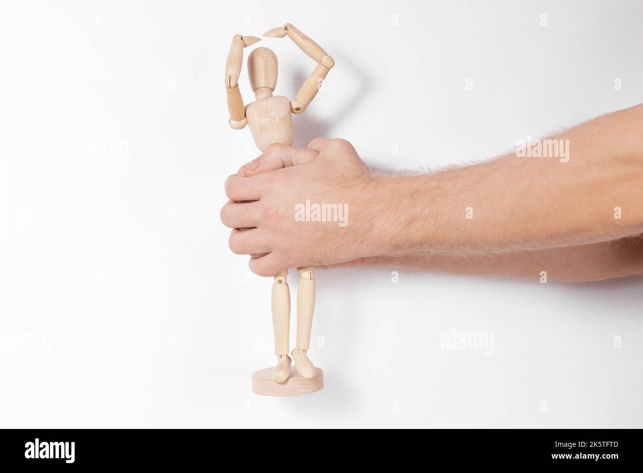 male hand holding a wooden puppet isolated on white background Stock ...