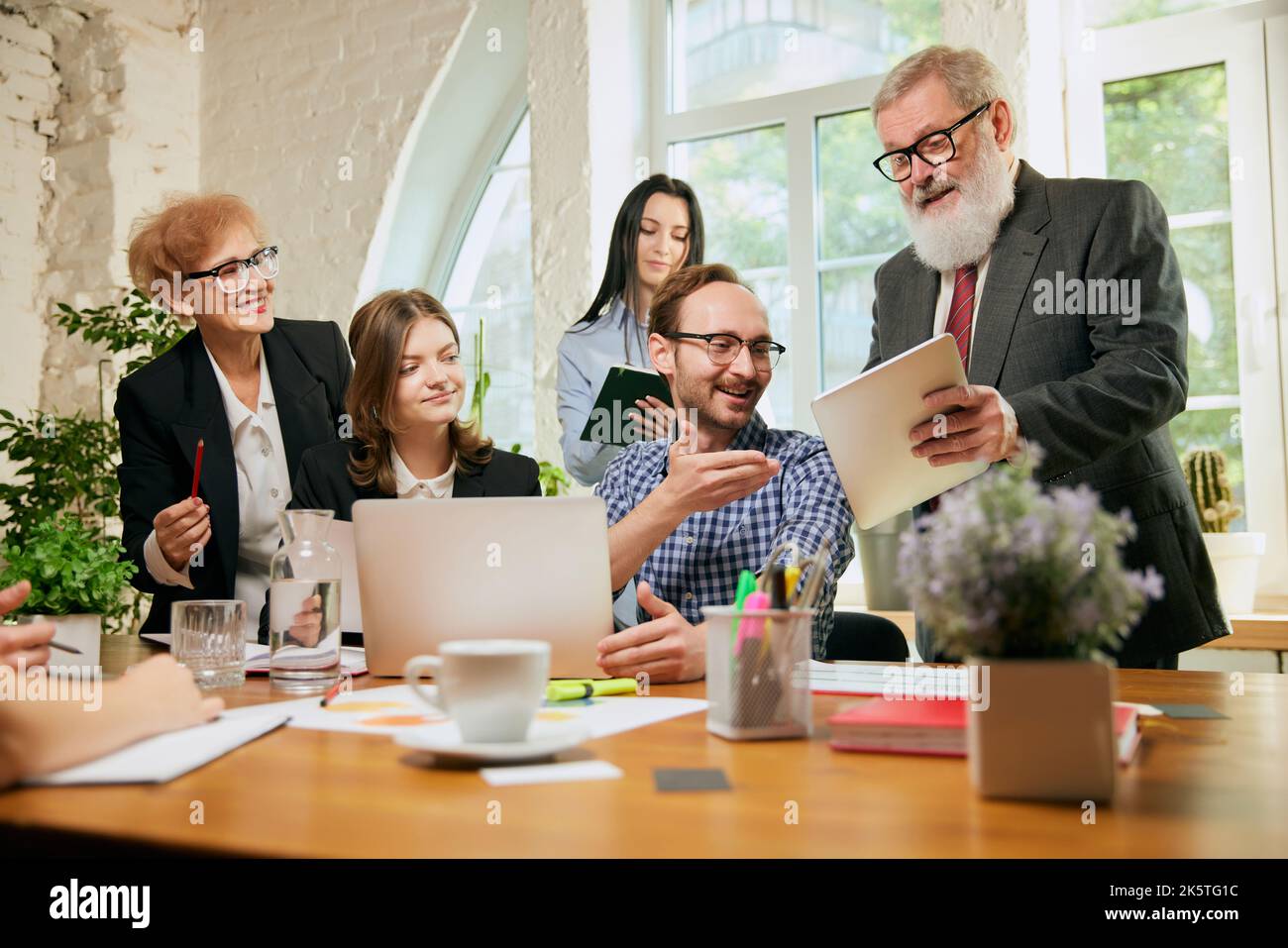 Group of mixed ages people talking, working with colleagues, co-workers ...