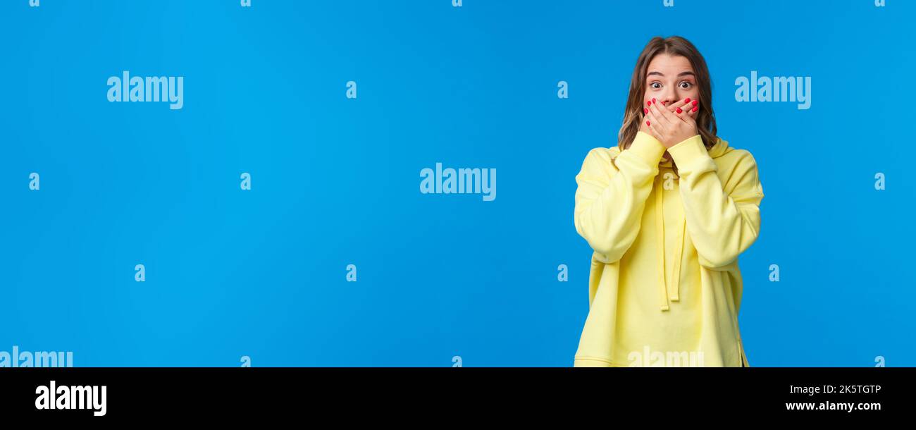 Shocked and speechless impressed blond woman close mouth with hands and ...