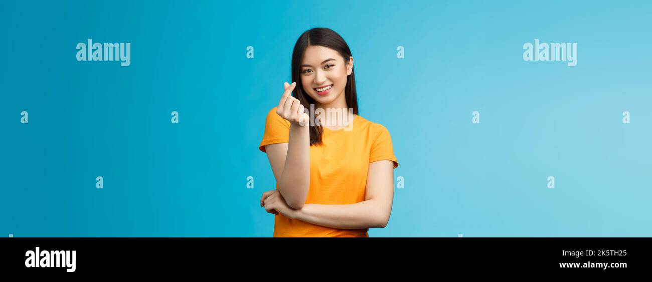 Cheerful cute asian woman dark short haircut, show korean heart sign ...