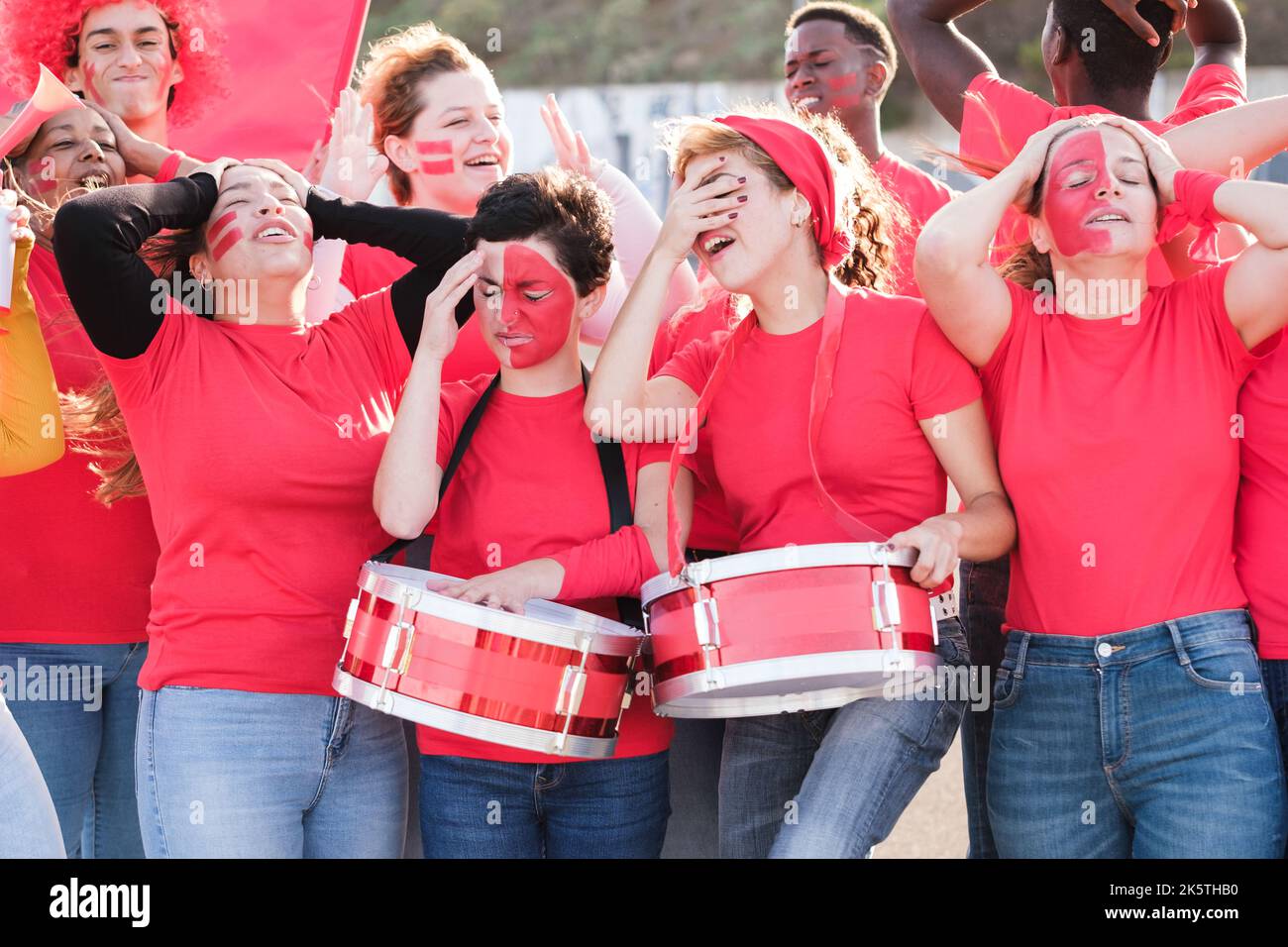 Group of sad fans with what happened to their team put their hands on ...