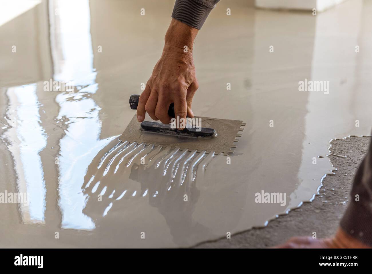 Construction workers are painting the floor using the method self ...