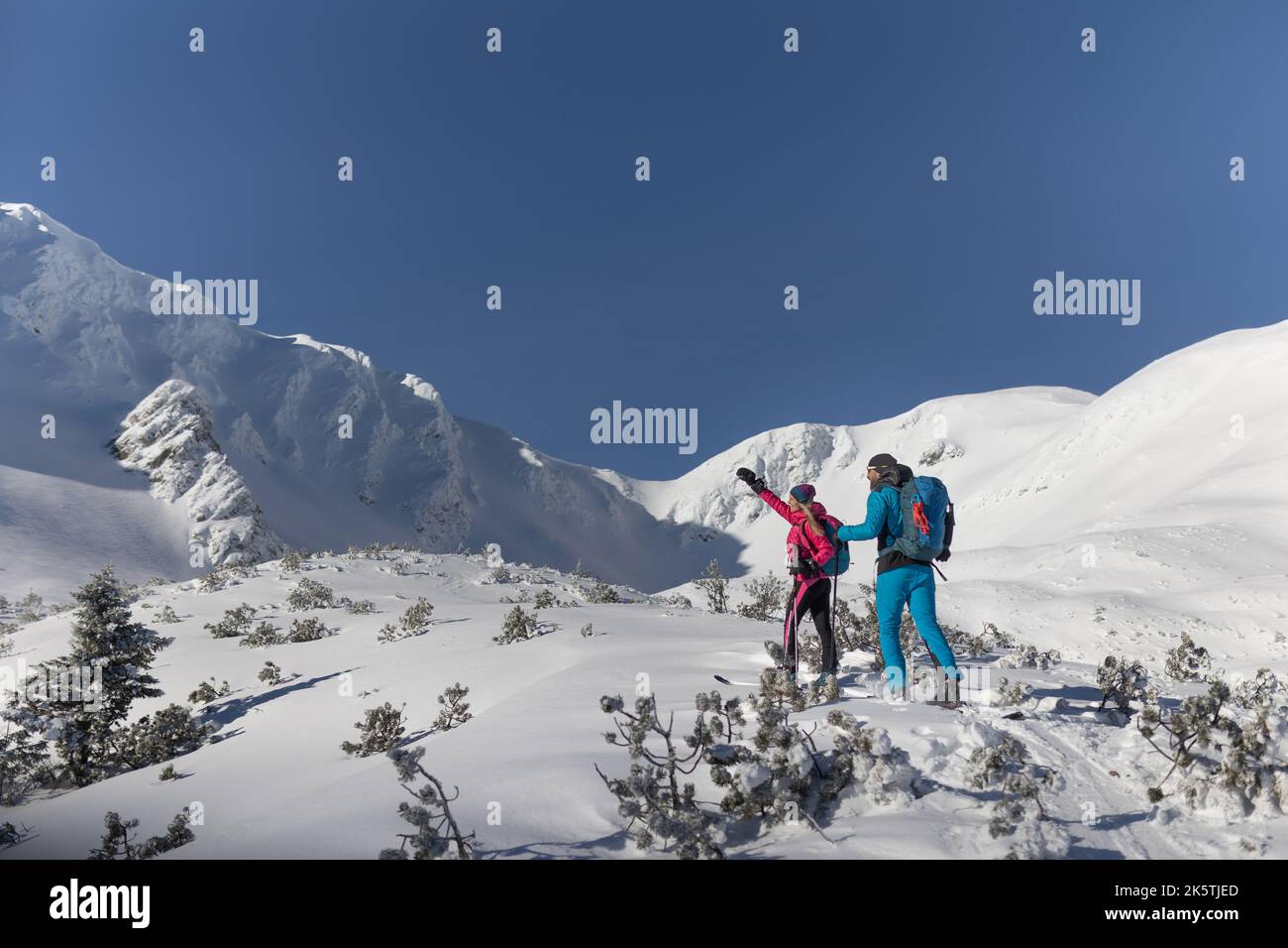 Low angle view of ski touring couple hiking up in mountains Stock Photo ...