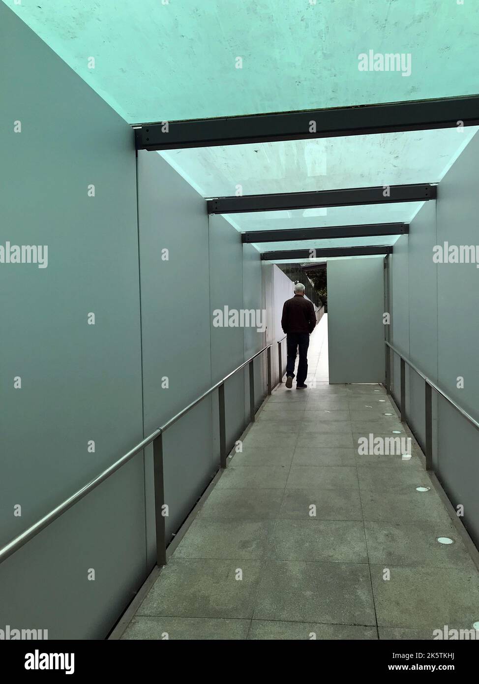 solitary male figure walking away from camera along covered walkway UEA ...