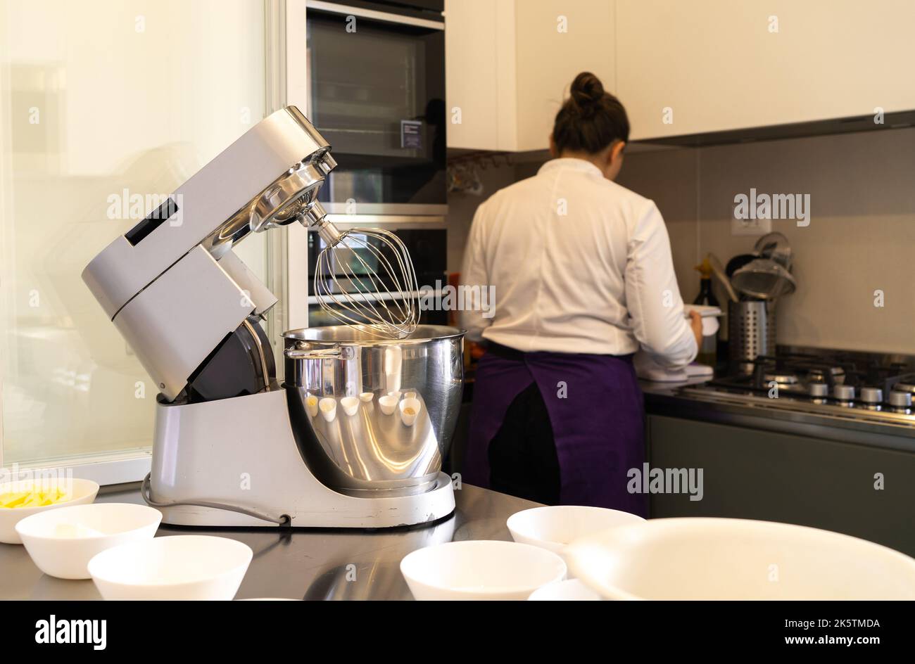 curvy young pastry chef from behind working in the making of a cake in ...