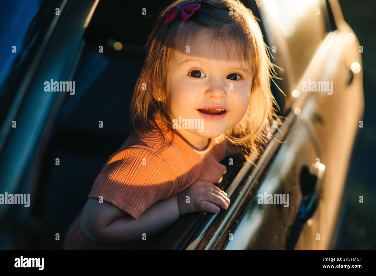 Baby boy in the car looking throw window with a face amazed by the ...