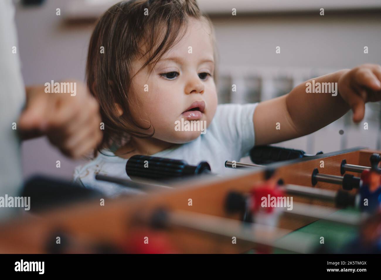 Close-up view of a concentrated child girl trying to learn how to play ...