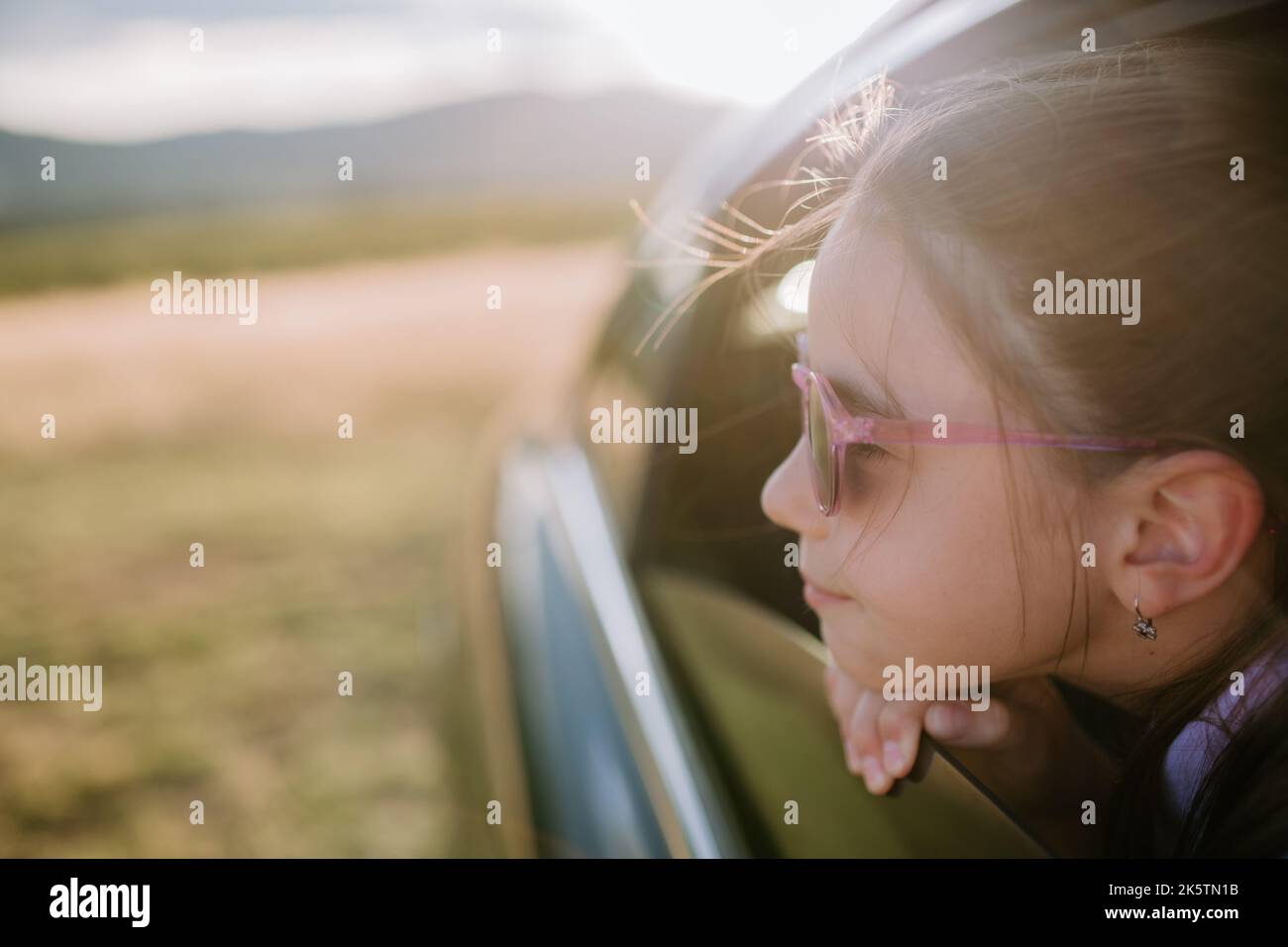 Little girl looking out of the car window during the ride Stock Photo ...