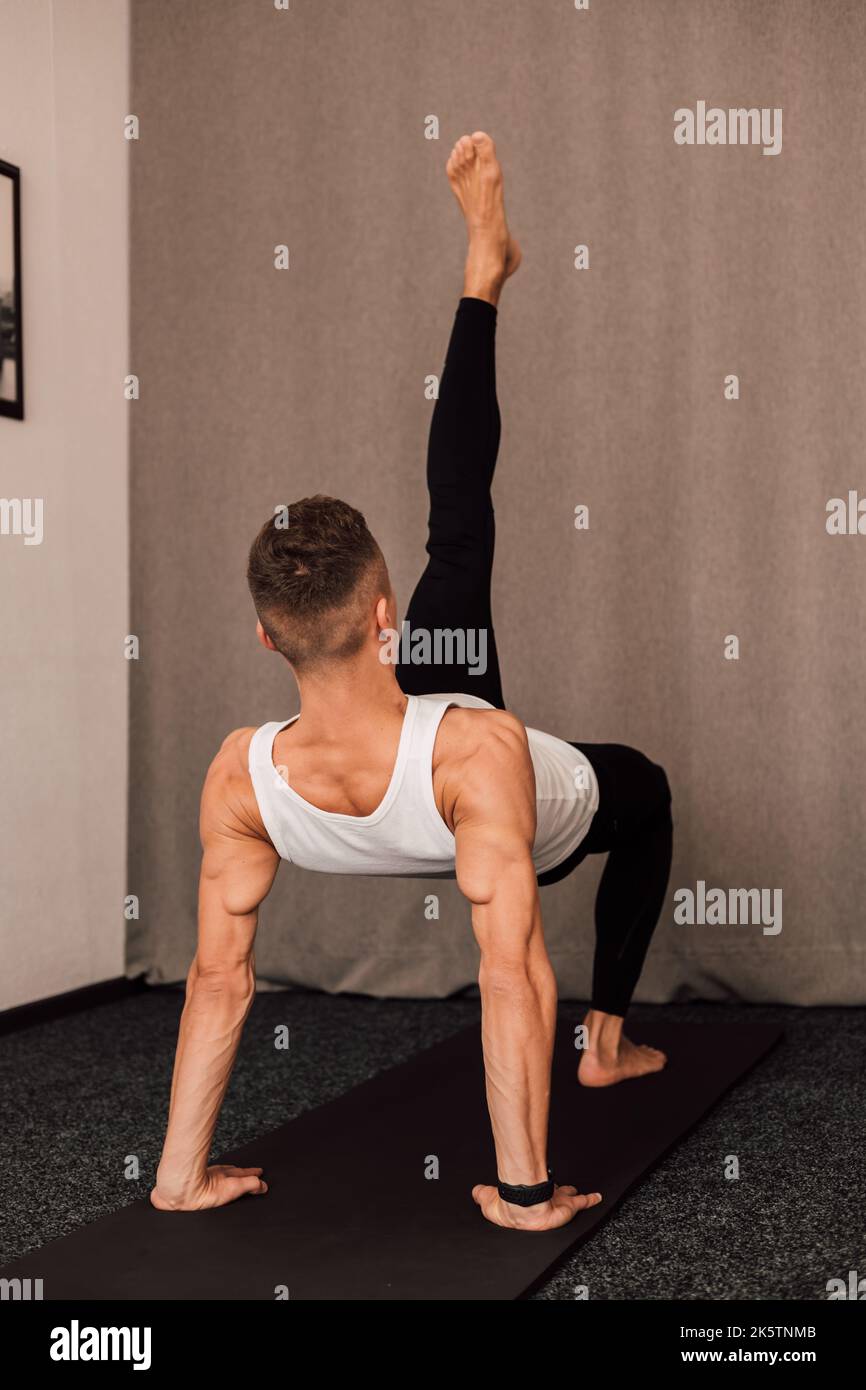 A young handsome athlete stands in a bar indoors. Rear view Stock Photo ...