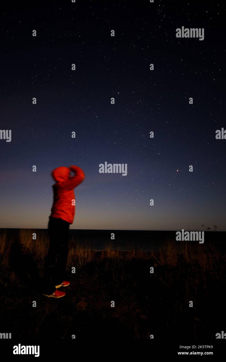 A human standing and looking at night sky with blsisful Milky way Stock ...