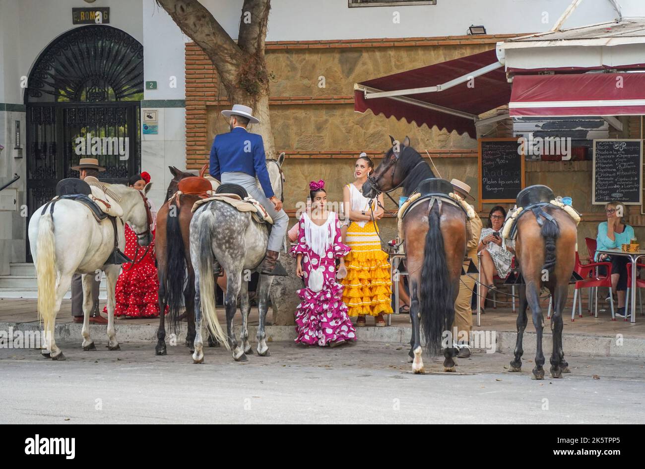 Spanish horsemen at a bar, with young women in traditional spanish ...