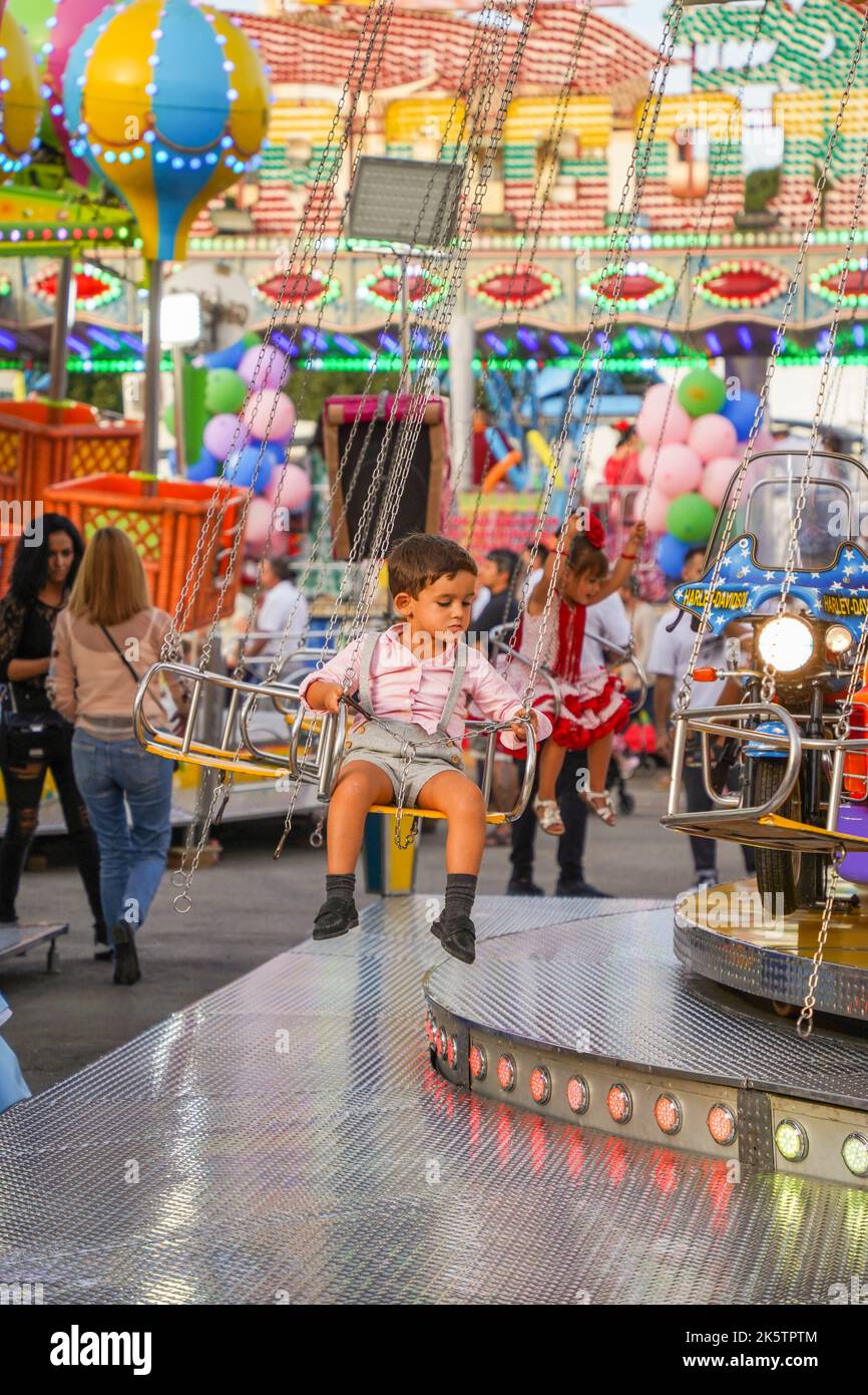Litlle boy at amusement ride attractions on annual Feria. funfair ...