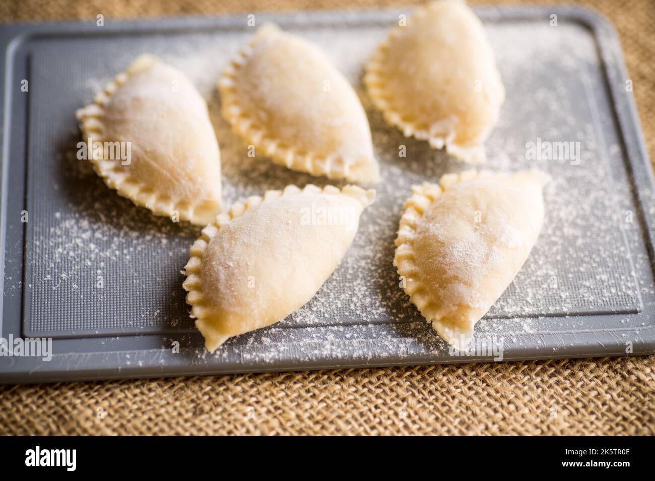 Raw dumplings with potatoes. Dumplings cooking on a kitchen cutting ...