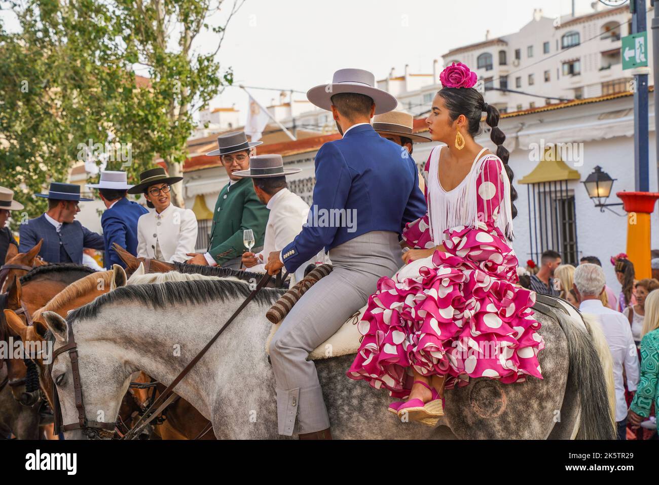 Spanish horseman at a bar, with young woman on back, during annual Fair ...