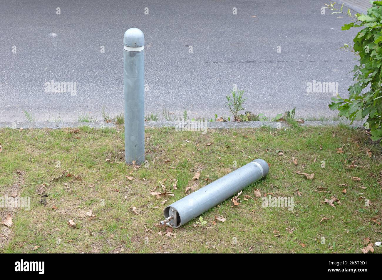 Pole at the side of a asphalt road, broken pole next to the standing ...