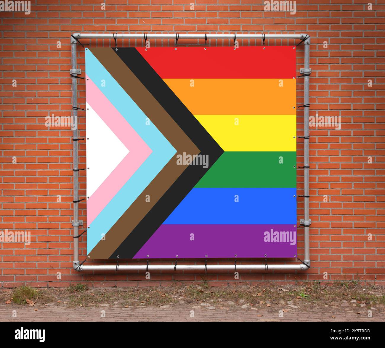 Banner on a brick wall, Progress LGBTQ Rainbow Flag Stock Photo - Alamy