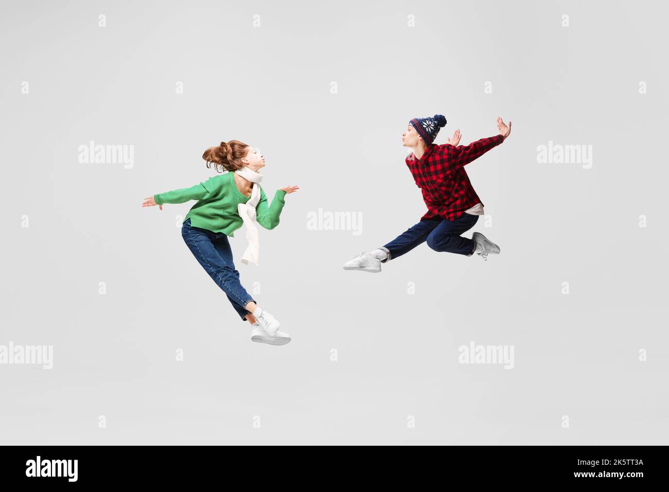Creative portrait of ballet dancers in warm clothes and hats dancing ...