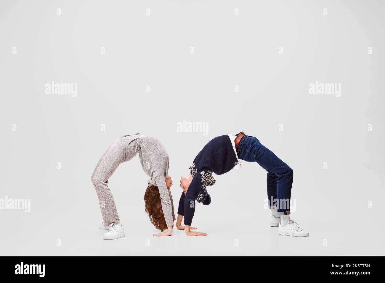 Bridge of understanding. Flexible girl and boy, ballet dancers in warm ...