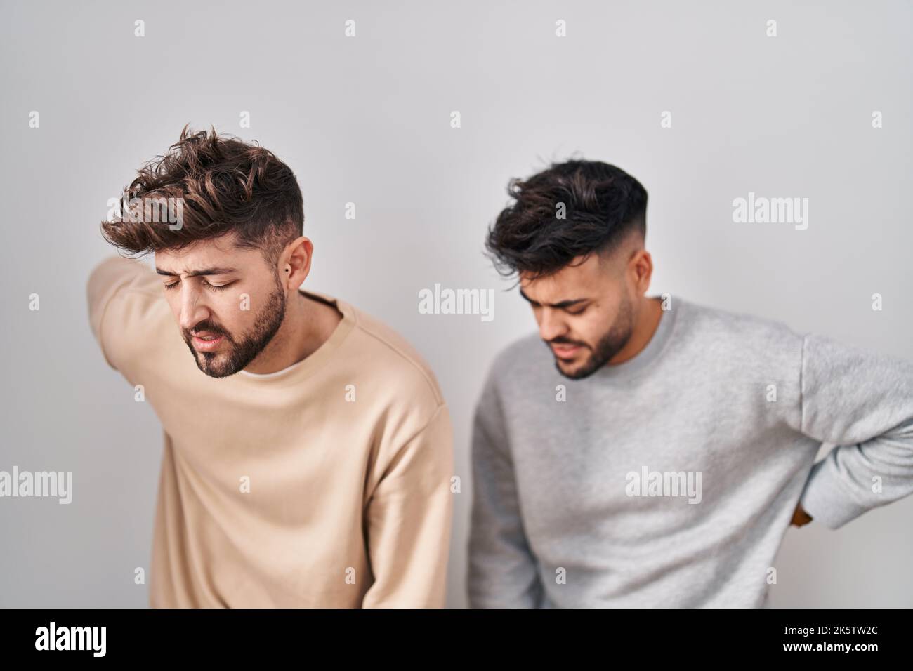 Young homosexual couple standing over white background suffering of ...