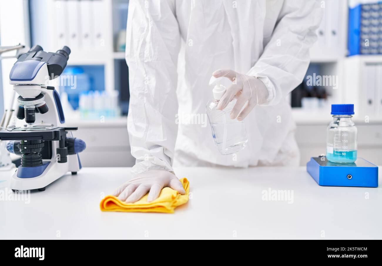 Young hispanic man scientist cleaning table at laboratory Stock Photo ...