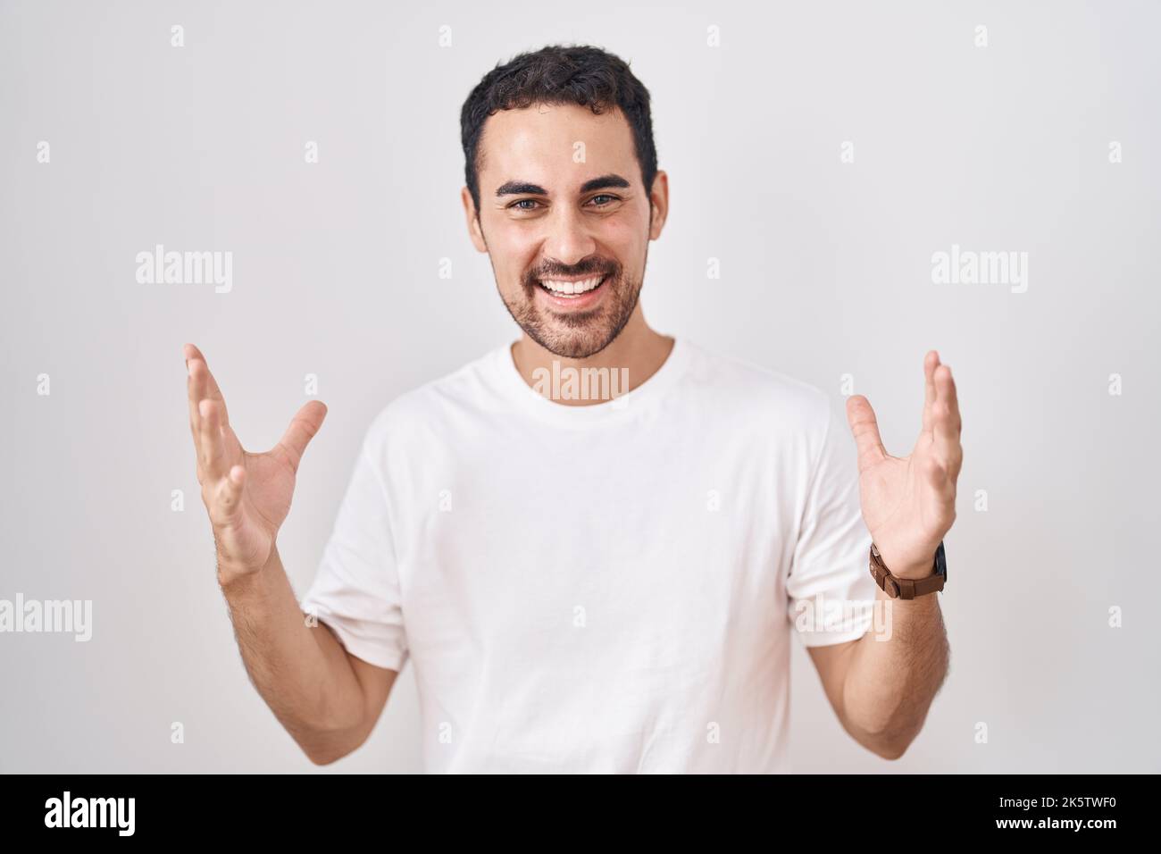 Handsome hispanic man standing over white background celebrating mad ...