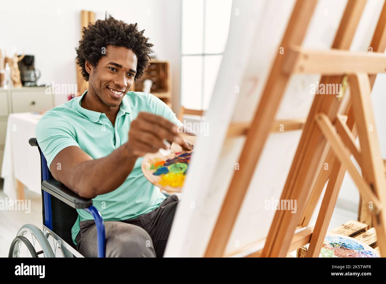 Young african american disabled artist man sitting on wheelchair ...
