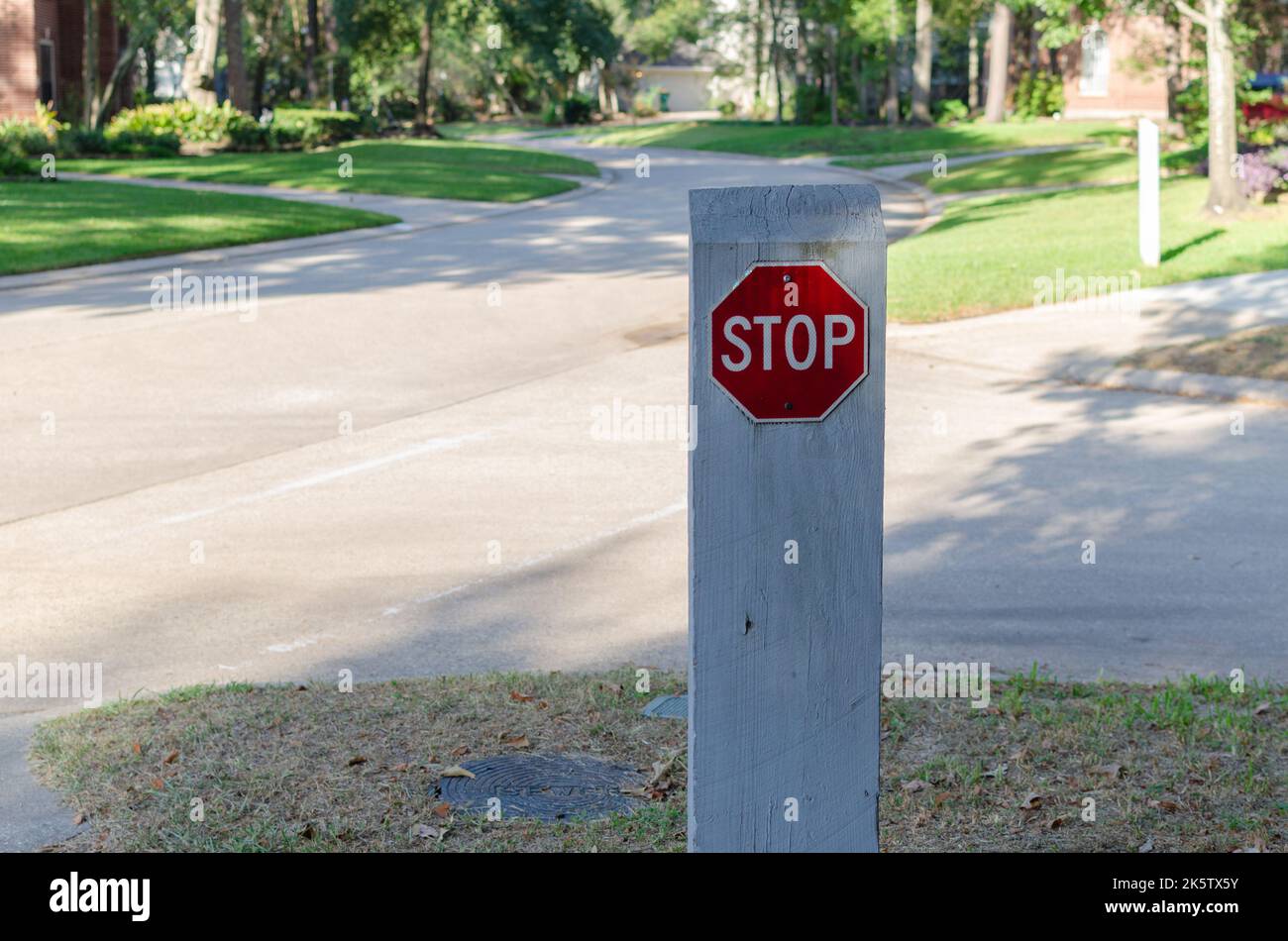A neighborhood intersection with a caution sign to stop for traffic ...