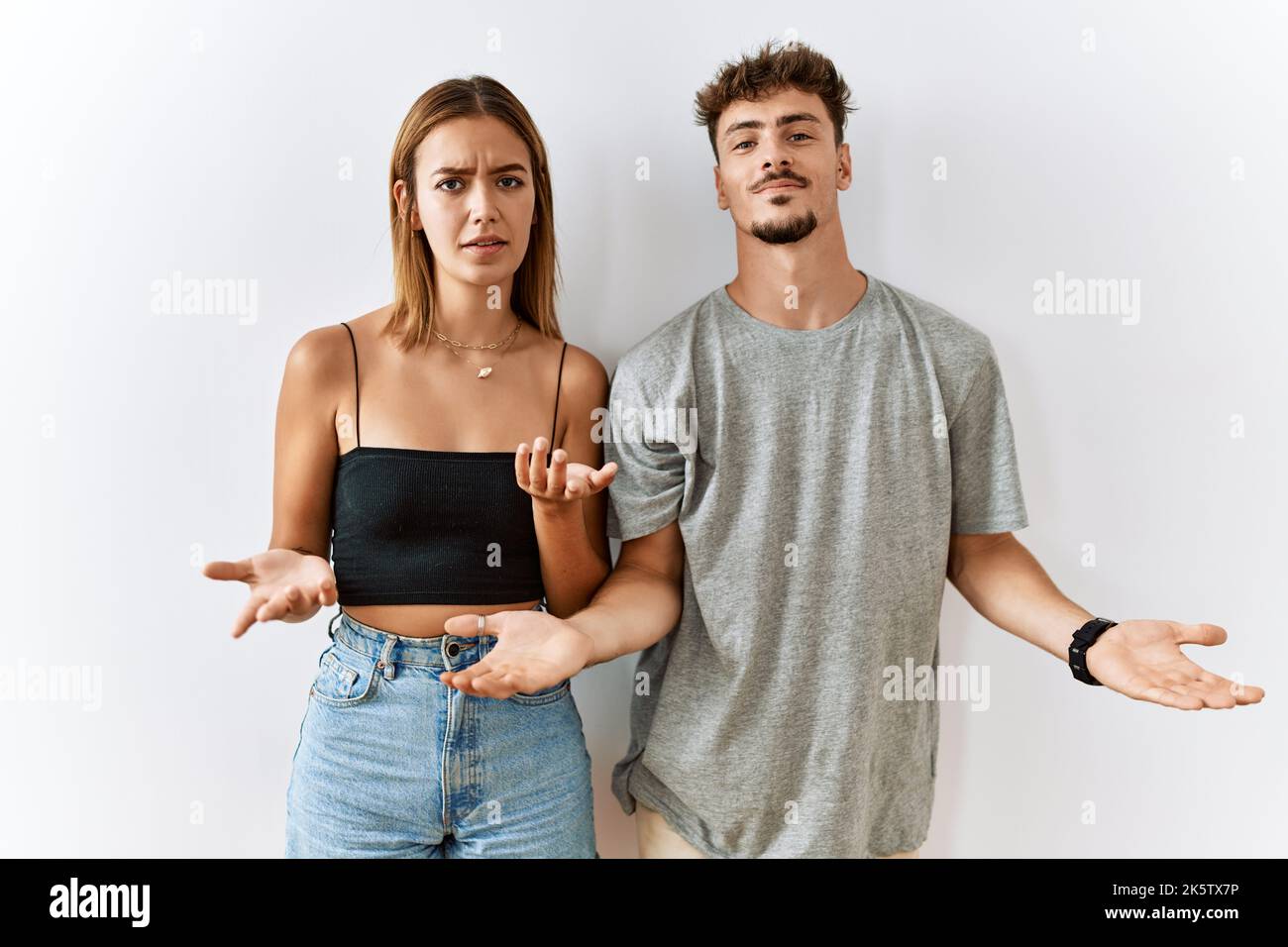 Young beautiful couple standing together over isolated background ...
