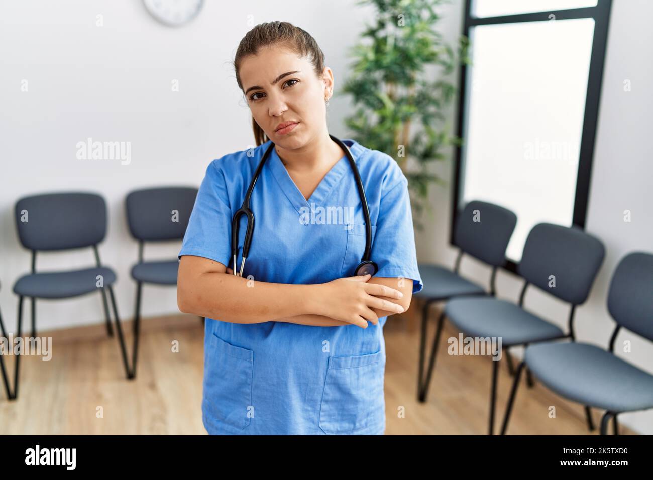 Young brunette doctor woman at waiting room skeptic and nervous ...