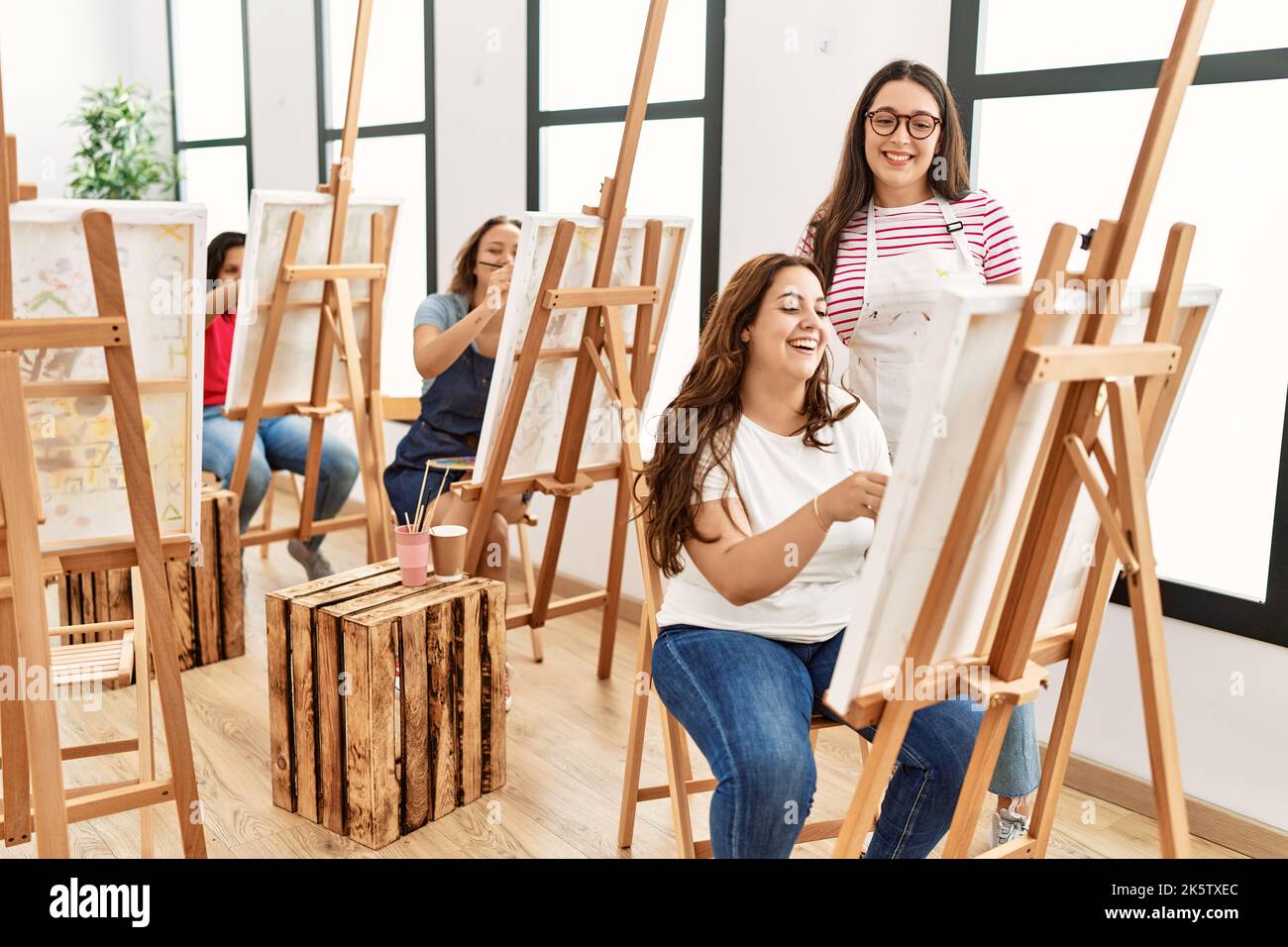 Art woman teacher smiling happy looking draw of paint student at studio ...