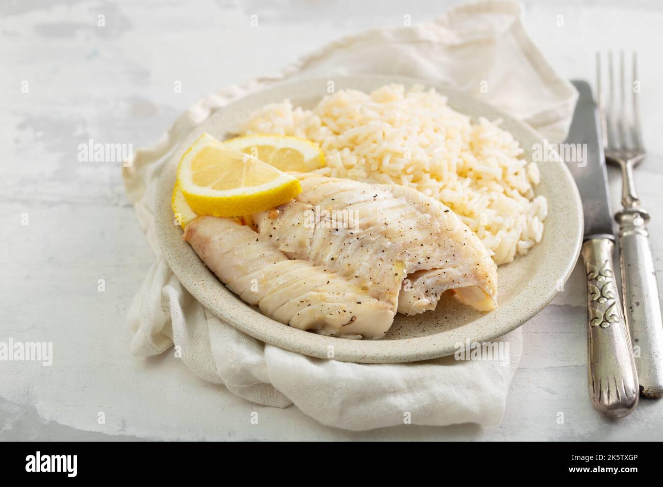 Fried fish fillet with boiled white rice on white dish Stock Photo - Alamy