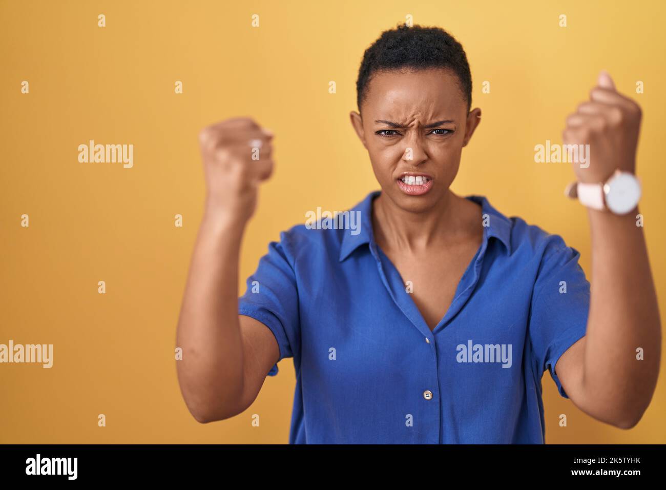 African american woman standing over yellow background angry and mad ...