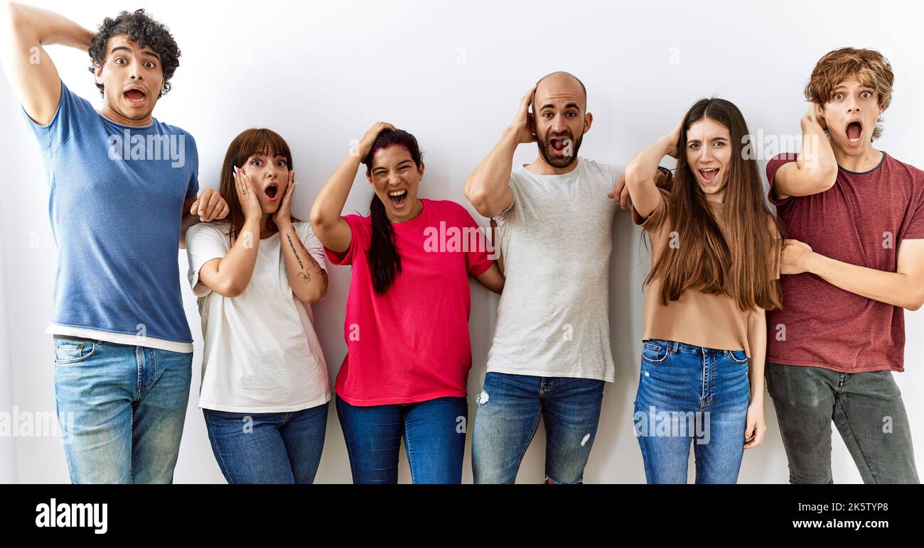 Group of young friends standing together over isolated background crazy ...