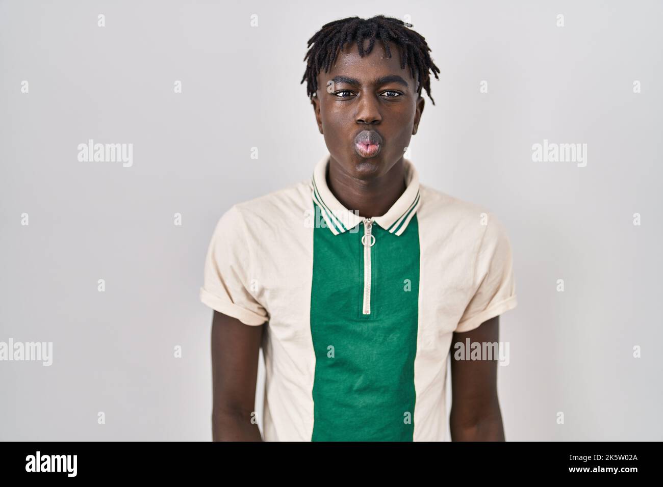 African man with dreadlocks standing over isolated background making ...