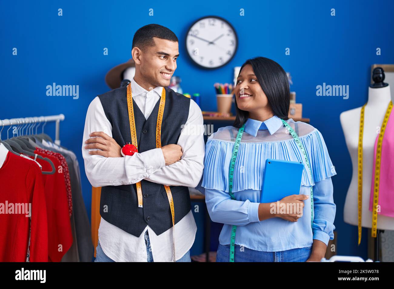 Man and woman tailors standing with arms crossed gesture holding ...