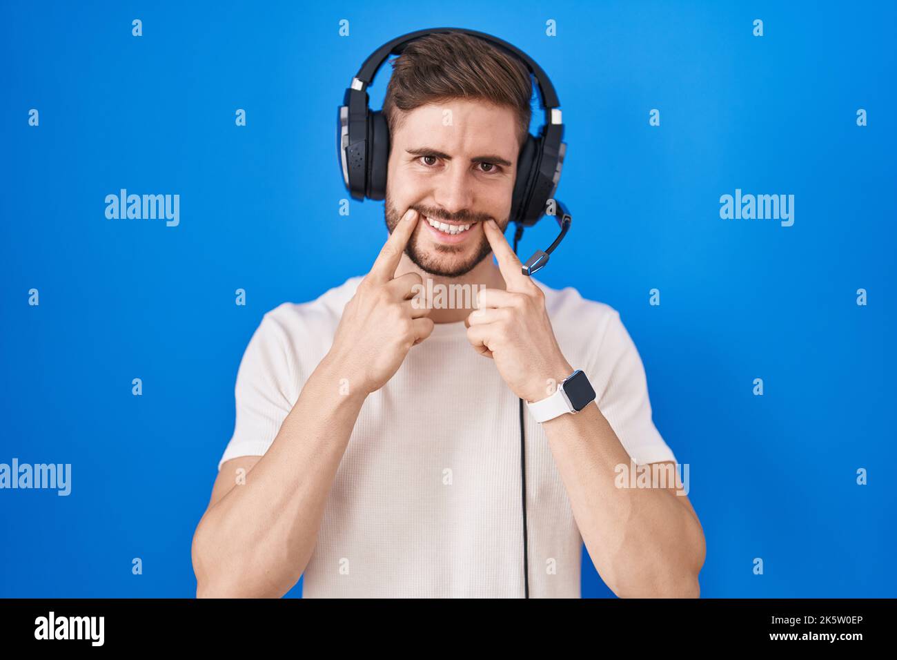 Hispanic Man With Beard Listening To Music Wearing Headphones Smiling