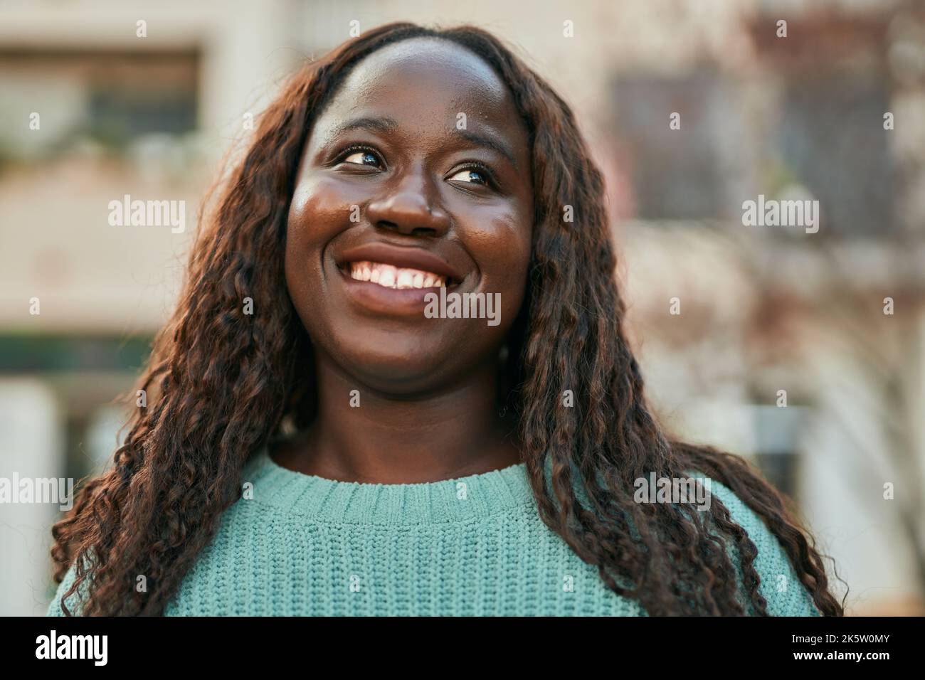 Young african woman smiling happy at the city Stock Photo - Alamy