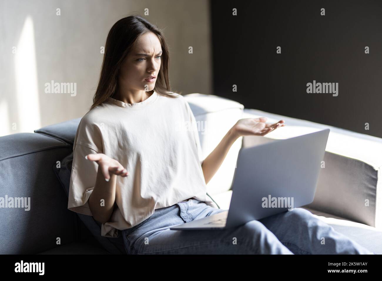 Stressed dissatisfied young woman looking at laptop screen, touching ...