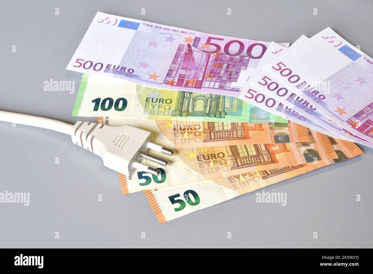 Electric plug with euro money banknotes over grey background. Concept ...
