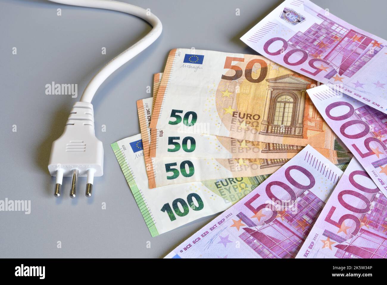 Electric plug with euro money banknotes over grey background. Concept ...