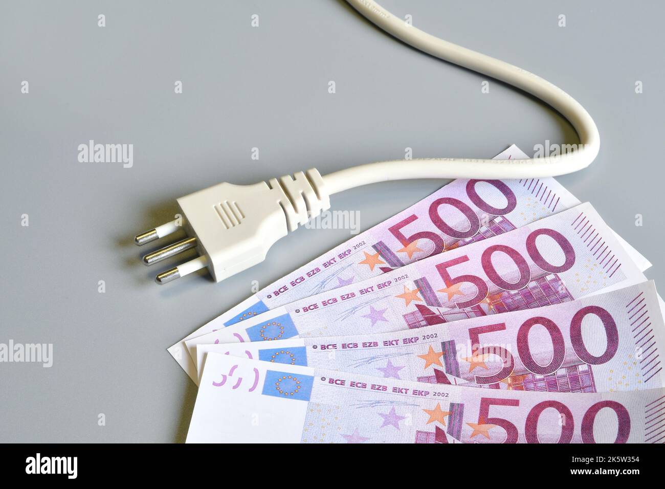 Electric plug with euro money banknotes over grey background. Concept ...