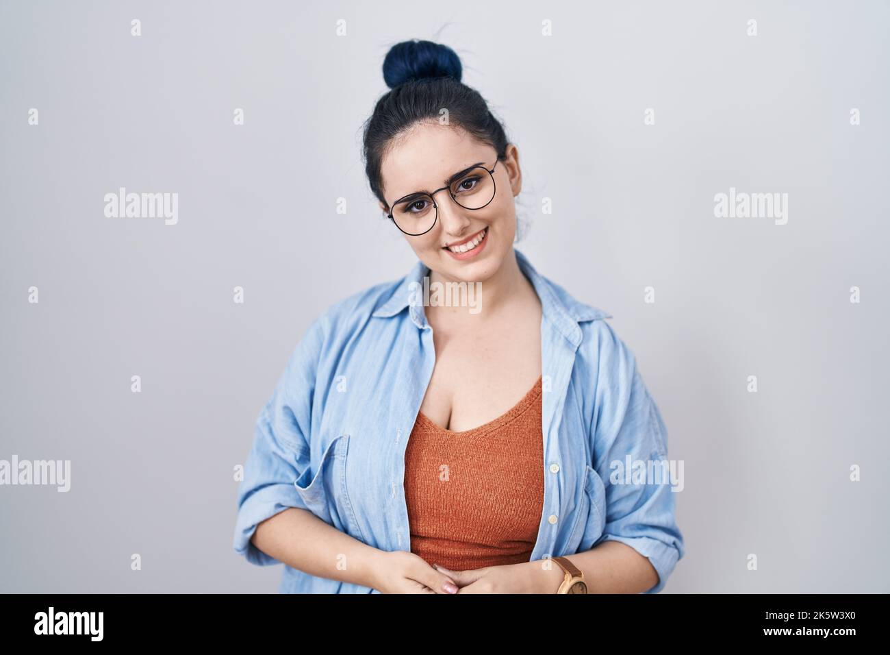 Young modern girl with blue hair standing over white background with ...