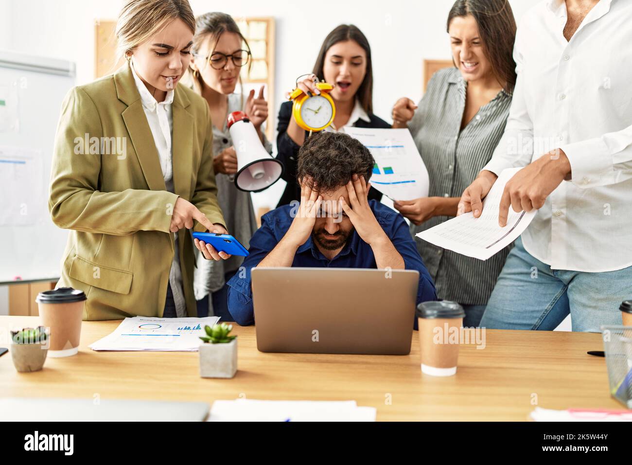 Group of business workers screaming to stressed partner at the office ...