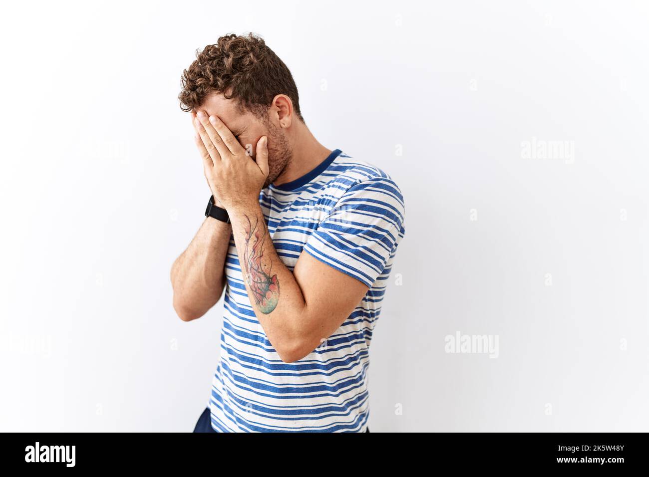 Handsome young man standing over isolated background with sad ...