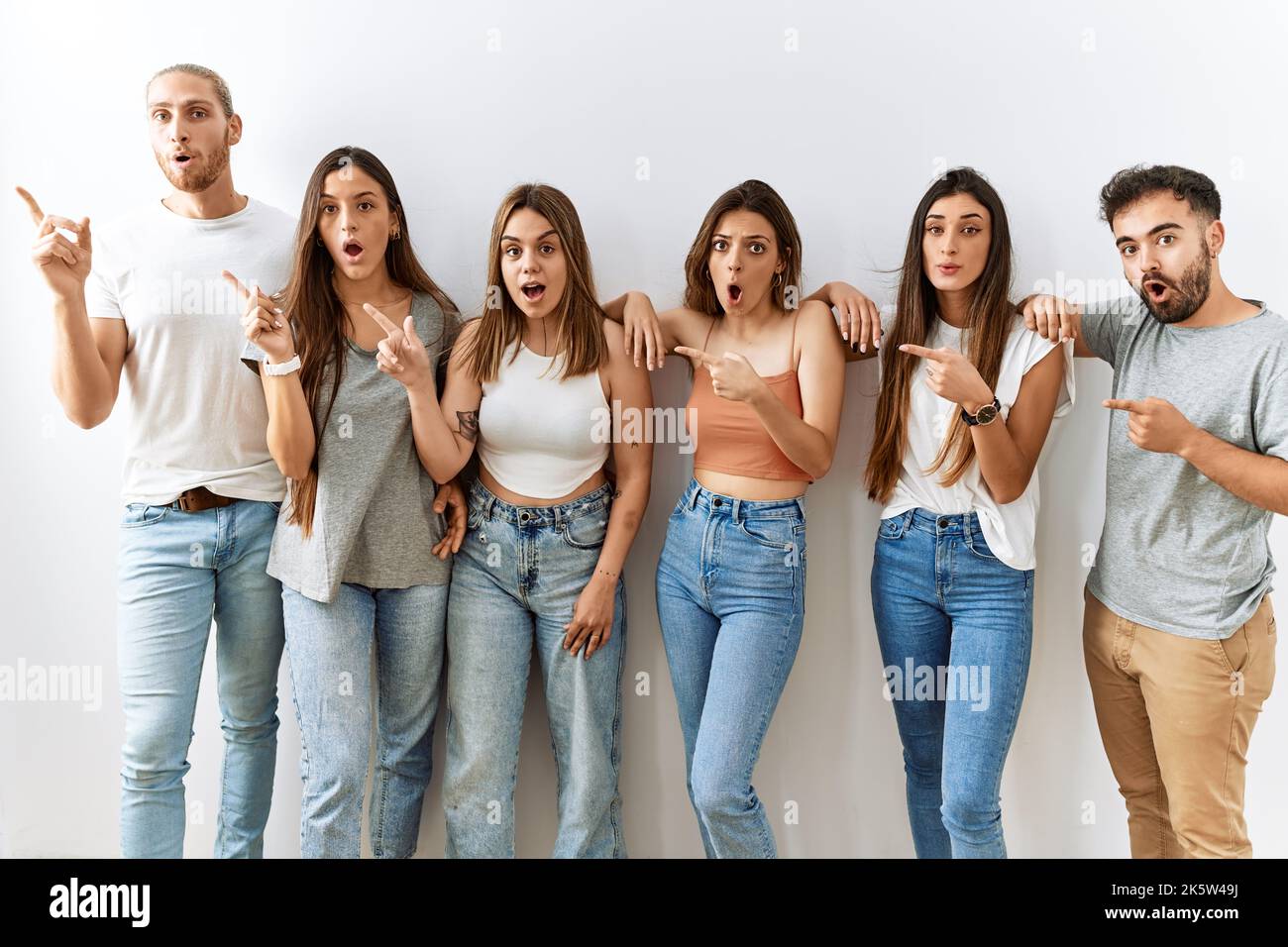 Group of young friends standing together over isolated background ...