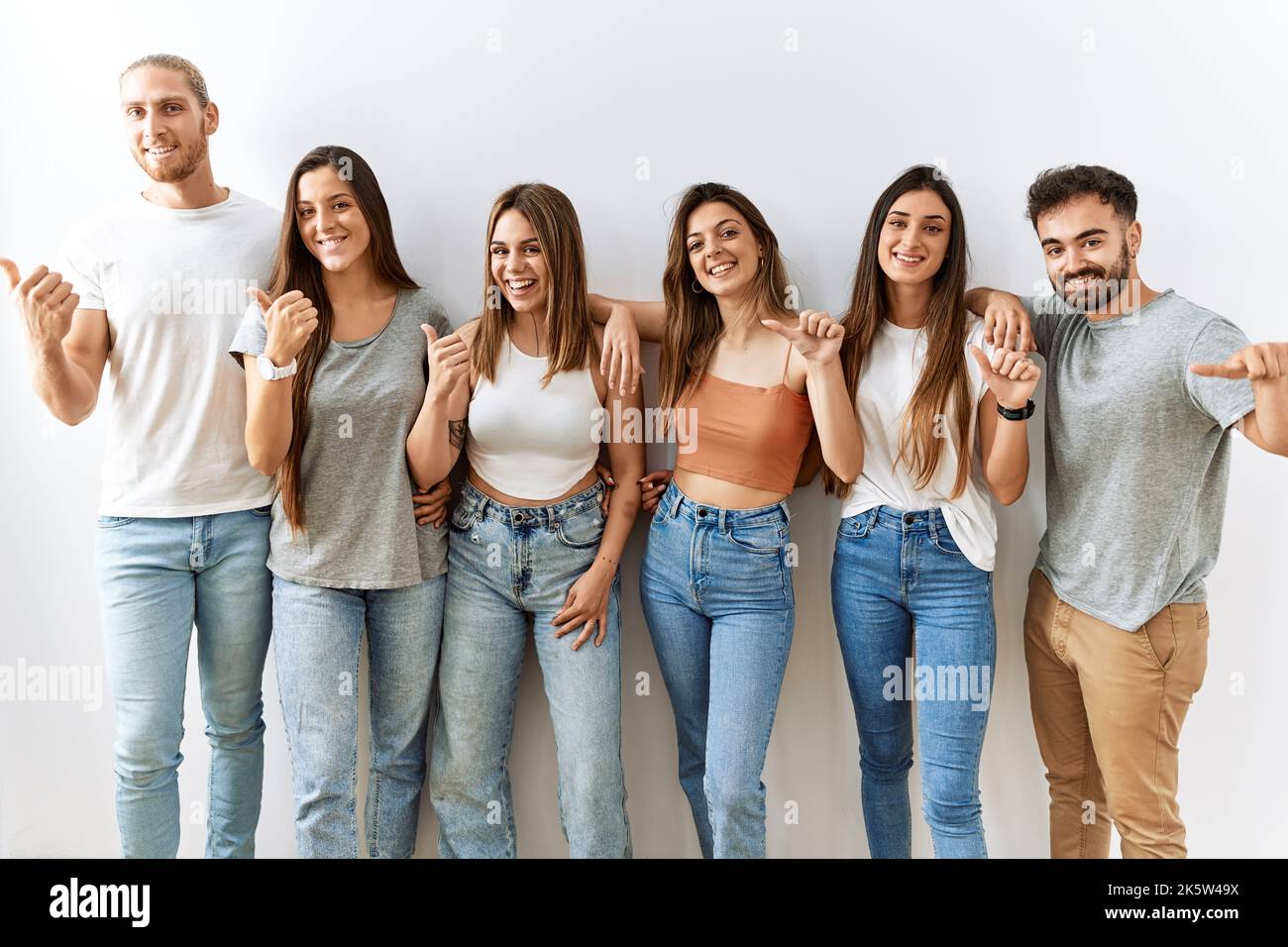 Group of young friends standing together over isolated background ...