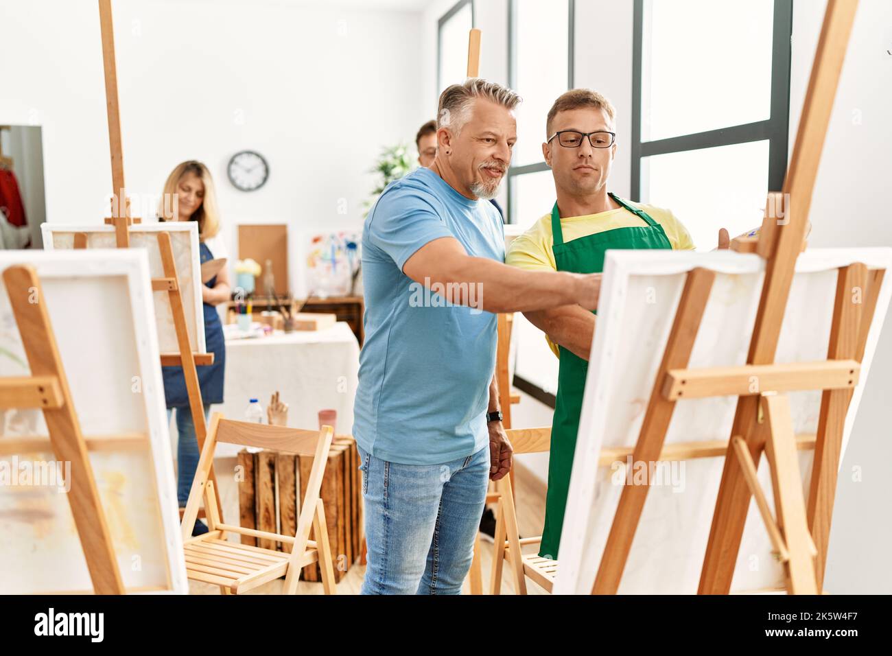 Group of middle age paint students drawing at art studio. Teacher ...