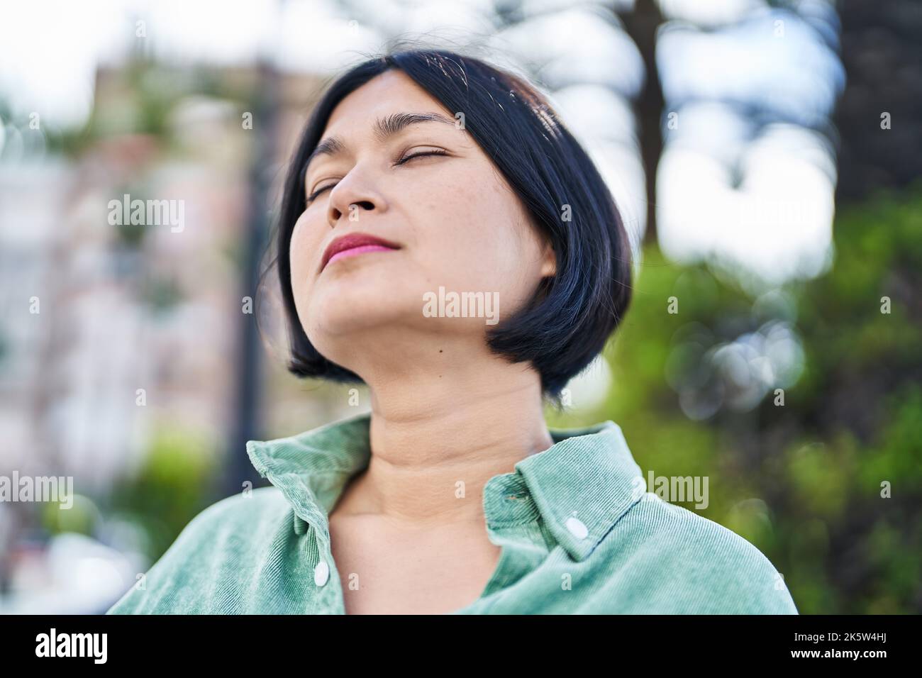 Young chinese woman breathing at park Stock Photo - Alamy